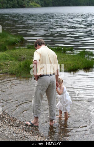 A little girl paddling in a stream. Bourton on the Water, The Cotswolds ...