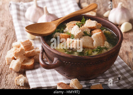 Homemade garlic soup with croutons close-up in a bowl on the table ...