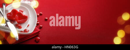 Valentines day table setting with plate, fork, knife, ring, ribbon and ...