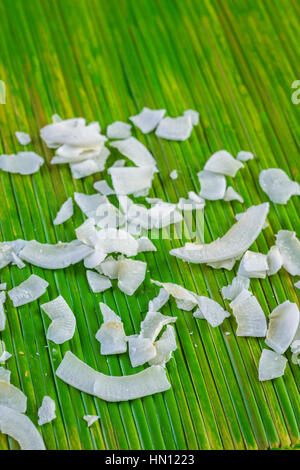 Dehydrated coconut flakes on a green background Stock Photo - Alamy