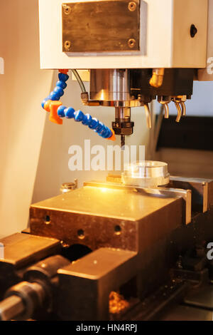A CNC milling machine milling heads in metal industry with coolant ...