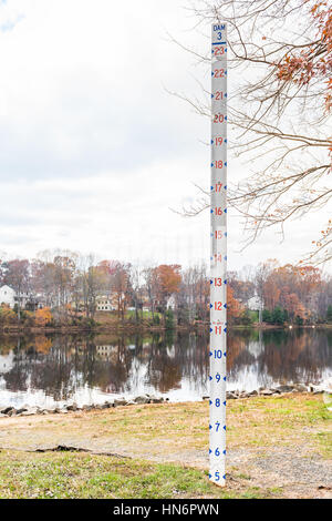 Meter or ruler for measuring water depth in a drainage canal against a ...