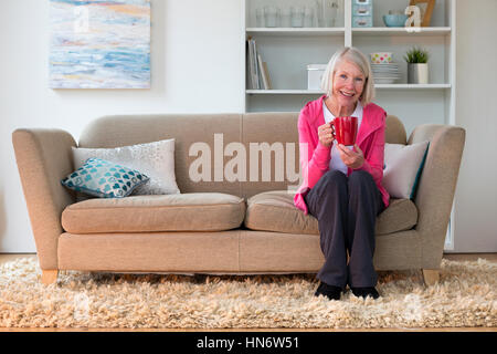 Grandma sitting at home in a comfortable armchair in the living room ...