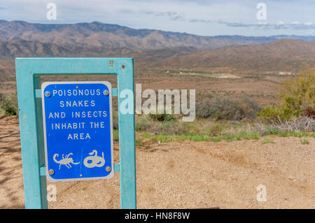Sign warning of poisonous snakes and insects at a rest area along ...
