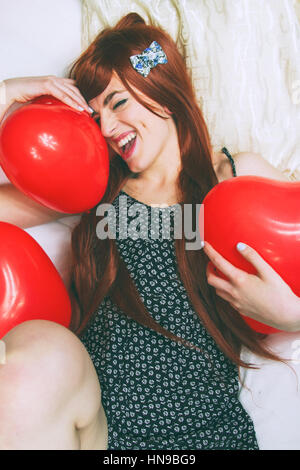Woman with heart shaped balloons for Valentine's Day on light ...