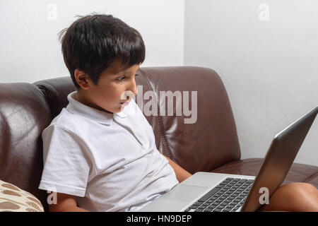 Child watching computer laptop screen while mother works at night Stock ...
