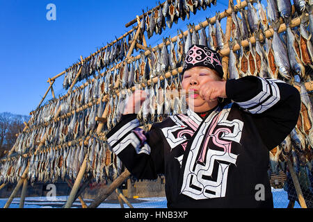 Ainu woman playing a traditional instrument in Ainu village museum ...