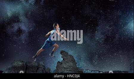 Young sportsman jogging against night sky background Stock Photo - Alamy
