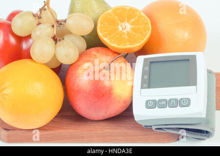 Vintage photo, Blood pressure monitor and fresh fruits with vegetables ...