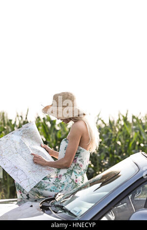 Side View Of Woman Reading Map While Standing Against Trees Stock Photo ...