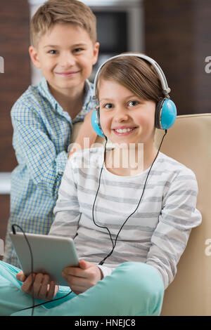 Cute girl with her brother listening music and dancing at home Stock ...