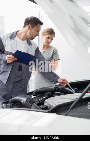 Engineer man and woman talking and explaining about robot arms ...