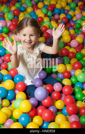 Young girl in ball pit throwing colored balls Stock Photo - Alamy
