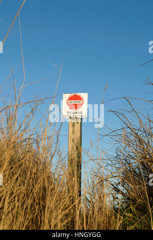 Golf course sign warning of flying golf balls with two golfers and a ...