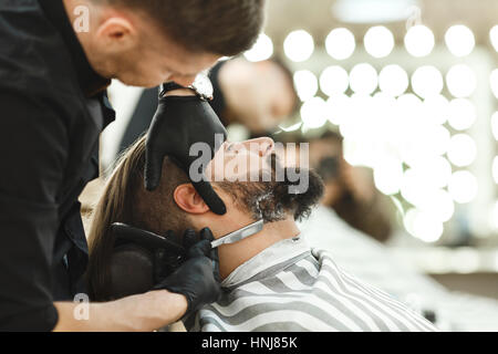Barber making beard form for man Stock Photo - Alamy