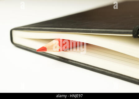 Colored pencil is inside the close notebooks Stock Photo - Alamy