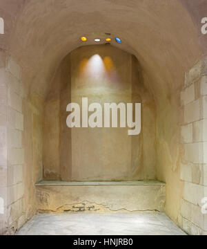 Arched stone wall lighted by glass roof holes at a historical ...