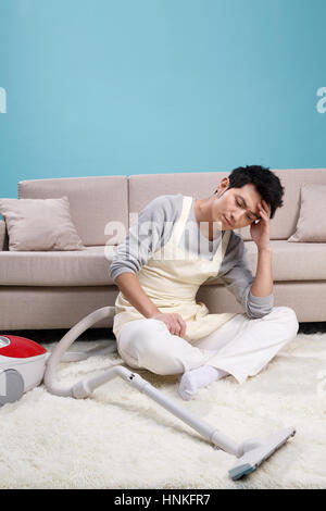 Young cleaner man with blue eyes cleaning wearing apron and gloves ...