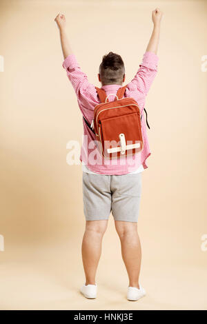 Rear view of man is carrying a pink gas cylinder on his shoulder ...