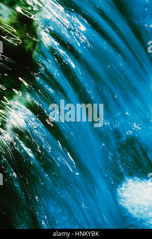 A vertical shot of a small waterfall in Aroser Weisshorn mountains ...