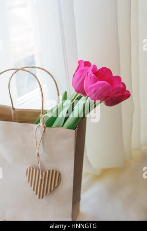 red tulips in paper bag with perfume. Flower card with beautiful ...