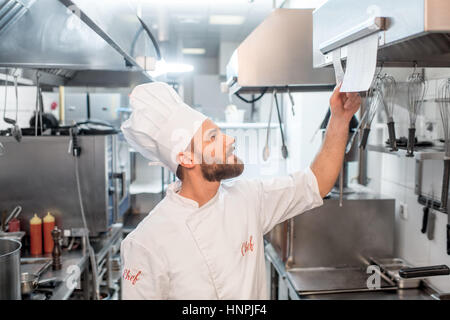 Chef cook checking the order at the restaurant kitchen Stock Photo - Alamy