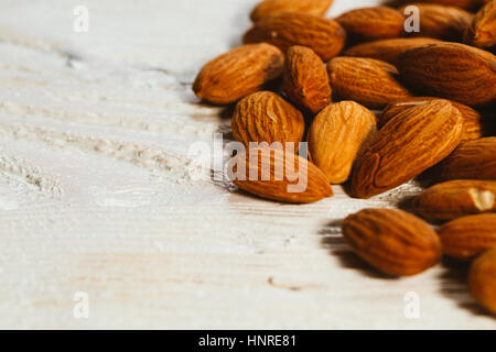 handful of almonds on a white wooden background Stock Photo - Alamy