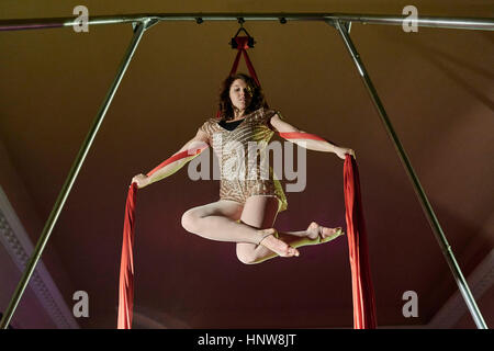 Young female acrobat poised hanging from hoop Stock Photo: 133955977 ...