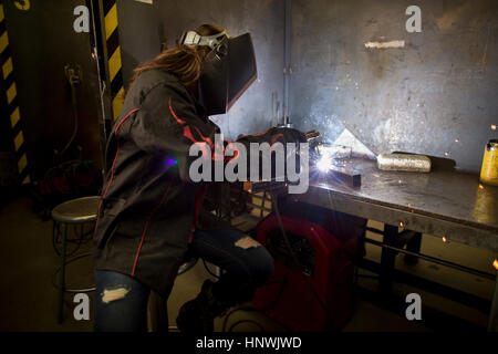 Female metalsmith welding metal at workbench Stock Photo - Alamy