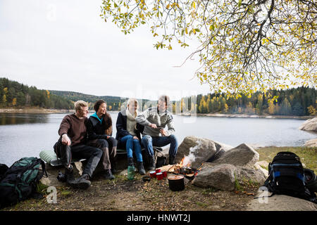 The young happy friends are preparing for camping. They're installing a ...