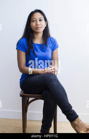 Woman sitting with folded legs on the bed Stock Photo - Alamy