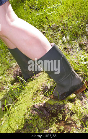 A female walking through thick mud on sodden wet ground. she is Stock ...