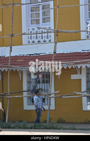 Indian workers on a bamboo scaffold give finishing touches to a huge ...