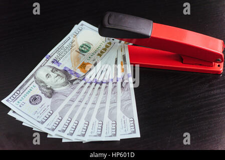 dollars and stapler on a black background Stock Photo - Alamy