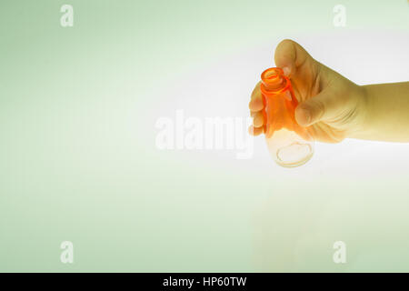 Little orange color bottle in hand Stock Photo - Alamy