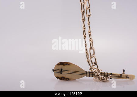 Chain tied to a Turkish musical instrument saz on a white background ...