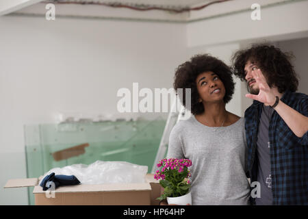 Happy young multiethnic couple unpacking or packing boxes and moving ...