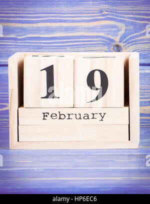 Cube shape calendar for February 19 on wooden surface with empty space ...