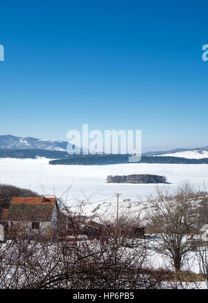 Landscape of Vlasina lake in winter with frozen water and snow covered ...