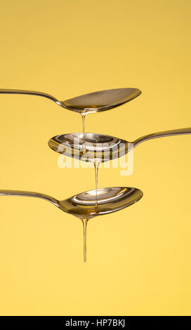 Pouring over three spoons Stock Photo - Alamy
