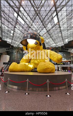 A canary yellow lamp teddy bear sculpture in the middle of the terminal ...