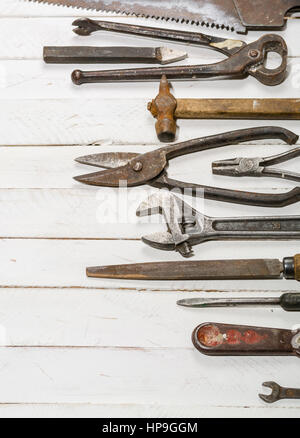 Tools scattered on a wooden workbench with a ratchet wrench and various ...