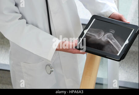 Female doctor using tablet computer while sitting at the workplace ...