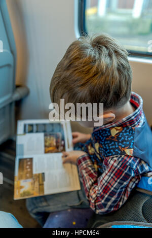 Boy reading book on the train Stock Photo: 309984960 - Alamy