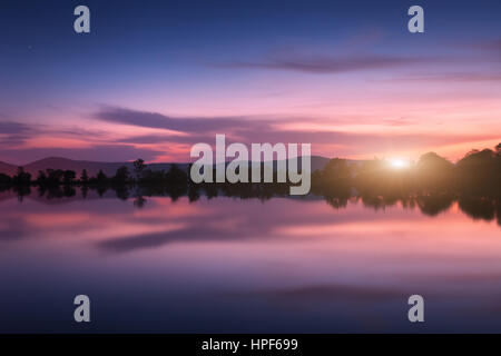 Mountain lake with moonrise at night. Night landscape with river, trees ...