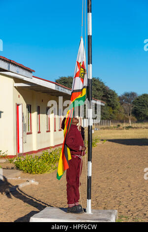 A school child raises the Zimbabwean flag at a rural school in ...