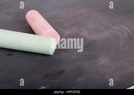 Sticks of coloured chalk on a dirty blackboard Stock Photo - Alamy