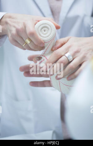 Doctor applying a plaster cast and bandages to patient forearm and ...