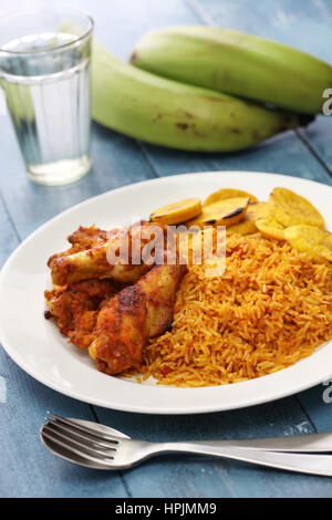 West African national cuisine. Jollof rice with grilled chicken wings ...