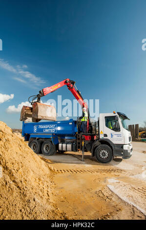 Grab tipper lorry picking up a load of aggregate Stock Photo - Alamy